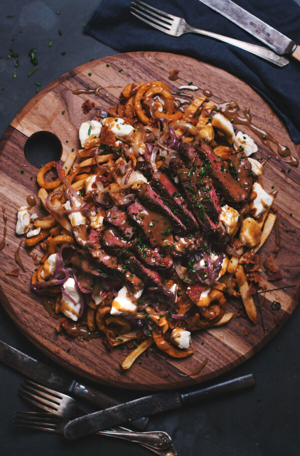 Deluxe poutine with beef ribeye steak, bacon and beer caramelized ...